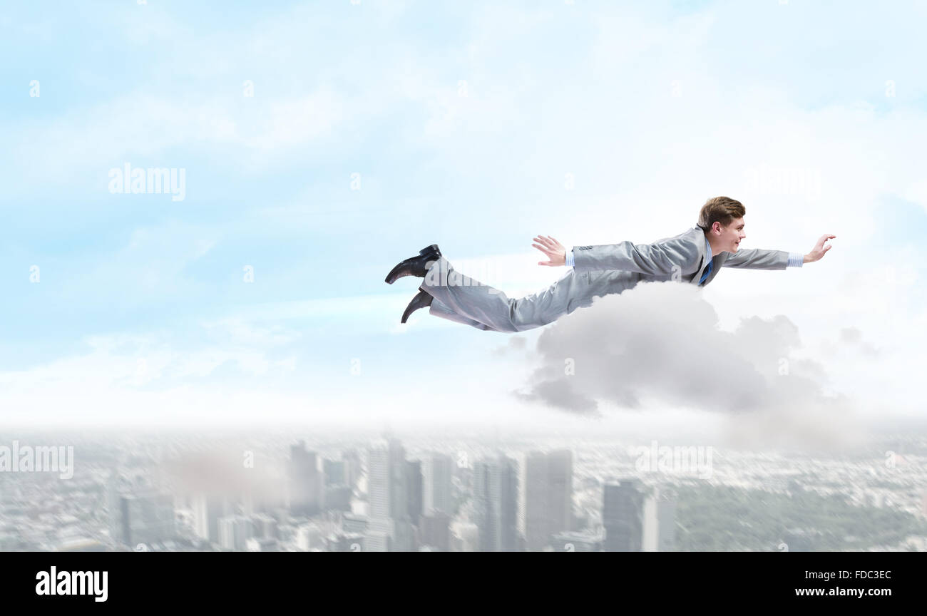 Young super businessman flying high in sky Stock Photo - Alamy