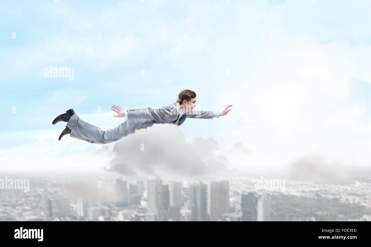 Young super businessman flying high in sky Stock Photo - Alamy