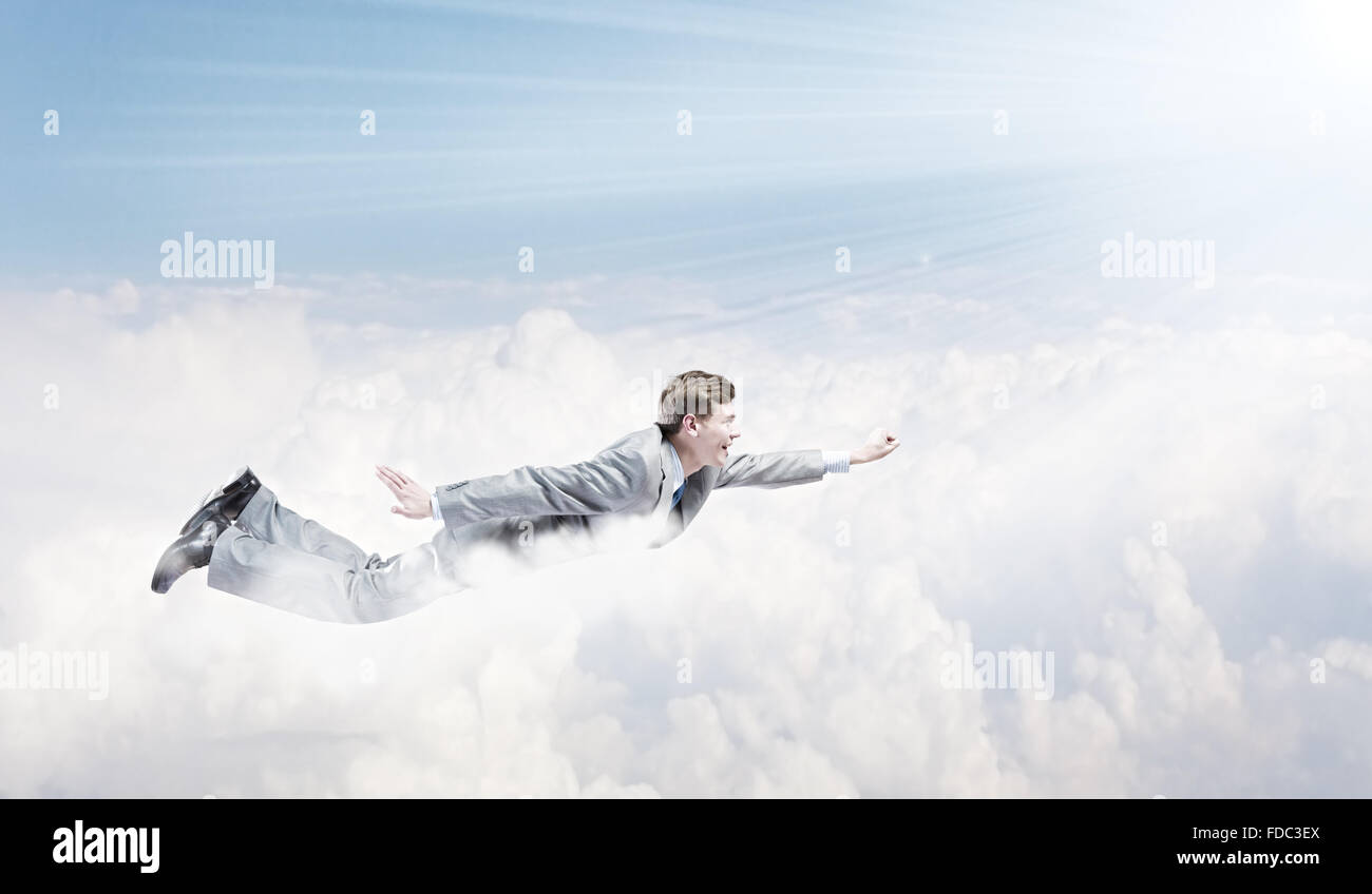 Young super businessman flying high in sky Stock Photo - Alamy