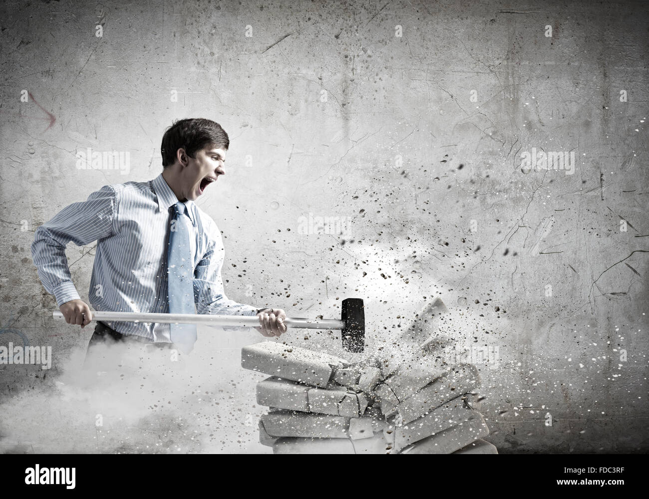 Young angry businessman crashing bricks with hammer Stock Photo - Alamy