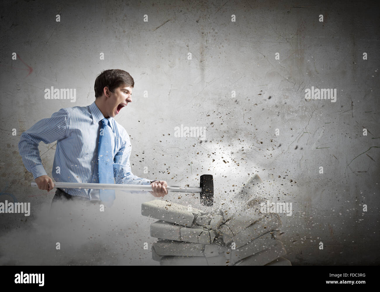 Young angry businessman crashing bricks with hammer Stock Photo - Alamy