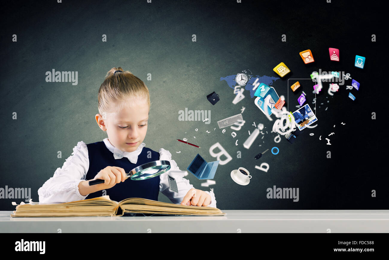 Schoolgirl examining opened book with magnifying glass Stock Photo - Alamy