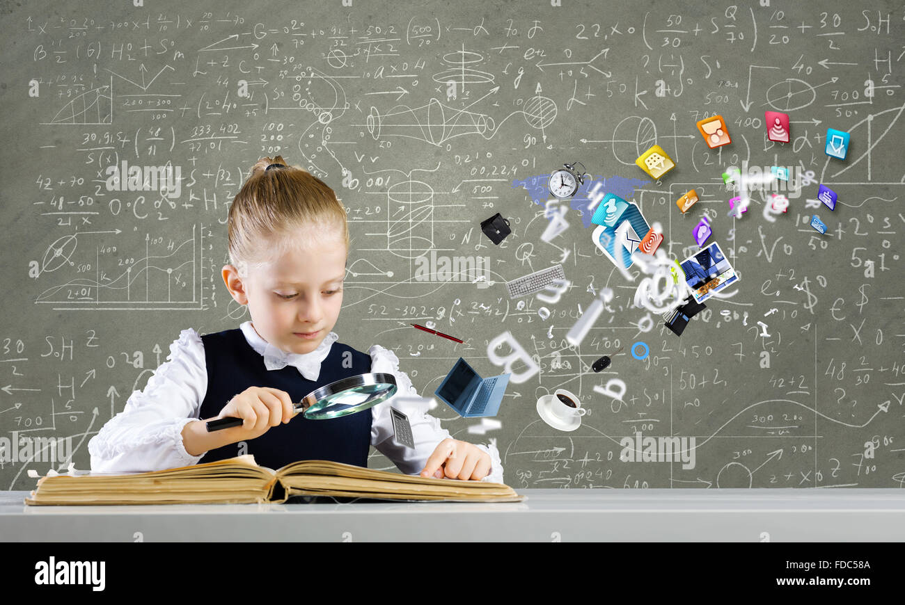 Schoolgirl examining opened book with magnifying glass Stock Photo - Alamy