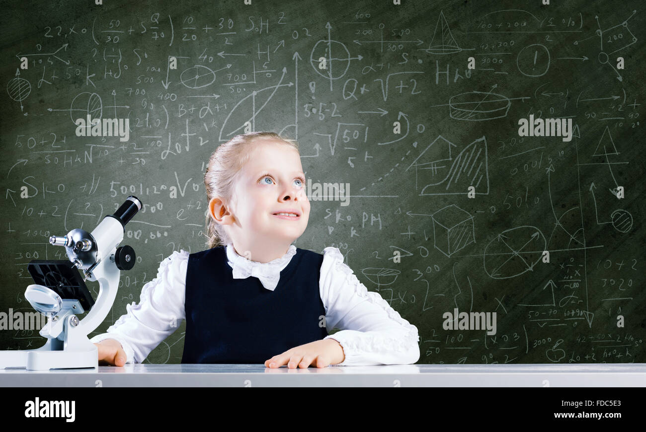 Cute school girl with microscope in classroom Stock Photo - Alamy
