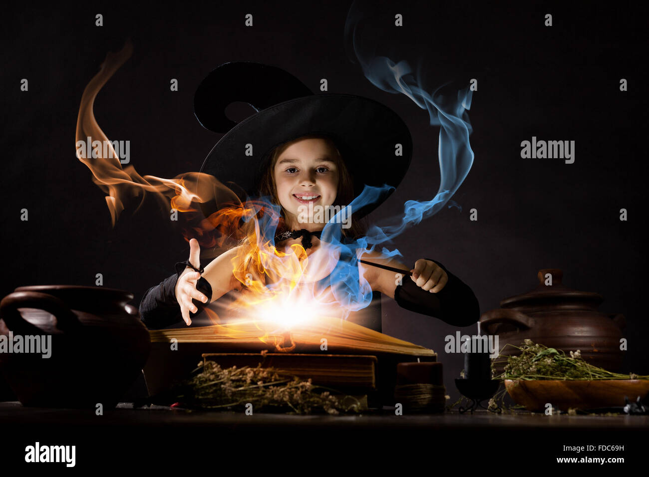 Little Halloween witch reading conjure from magic book Stock Photo - Alamy