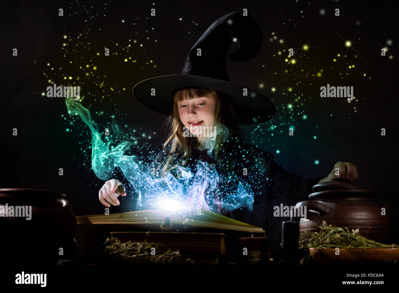 Little Halloween witch reading conjure from magic book Stock Photo - Alamy