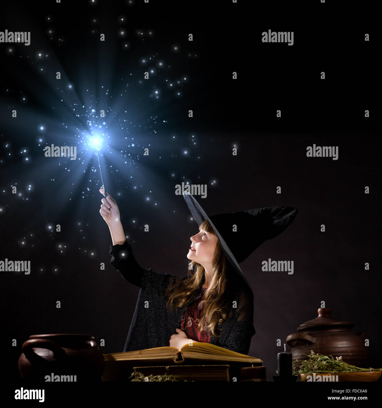 Little Halloween witch reading conjure from magic book Stock Photo - Alamy