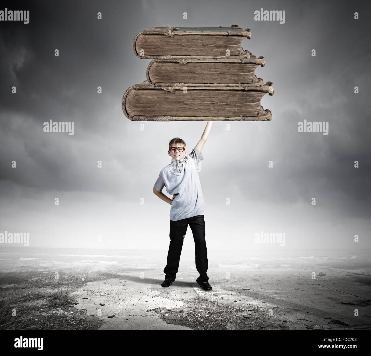 Young man holding huge book above head on one hand Stock Photo - Alamy