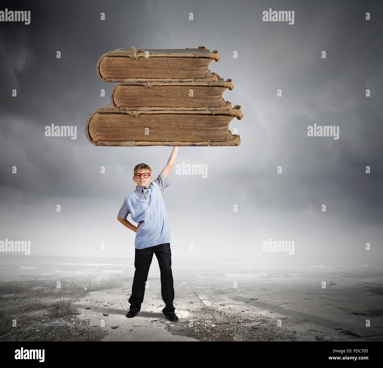 Young man holding huge book above head on one hand Stock Photo - Alamy
