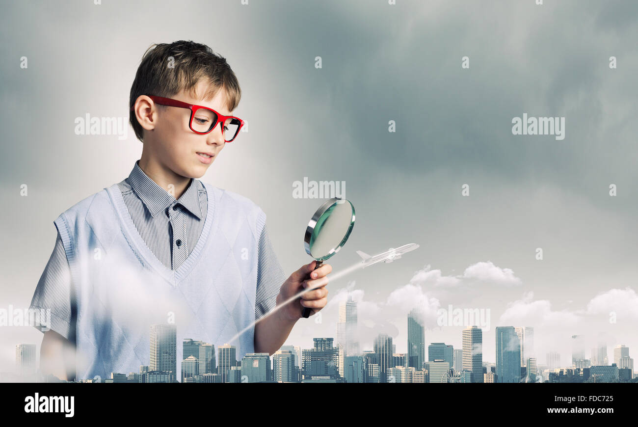 Cute school boy examining objects with magnifying glass Stock Photo - Alamy