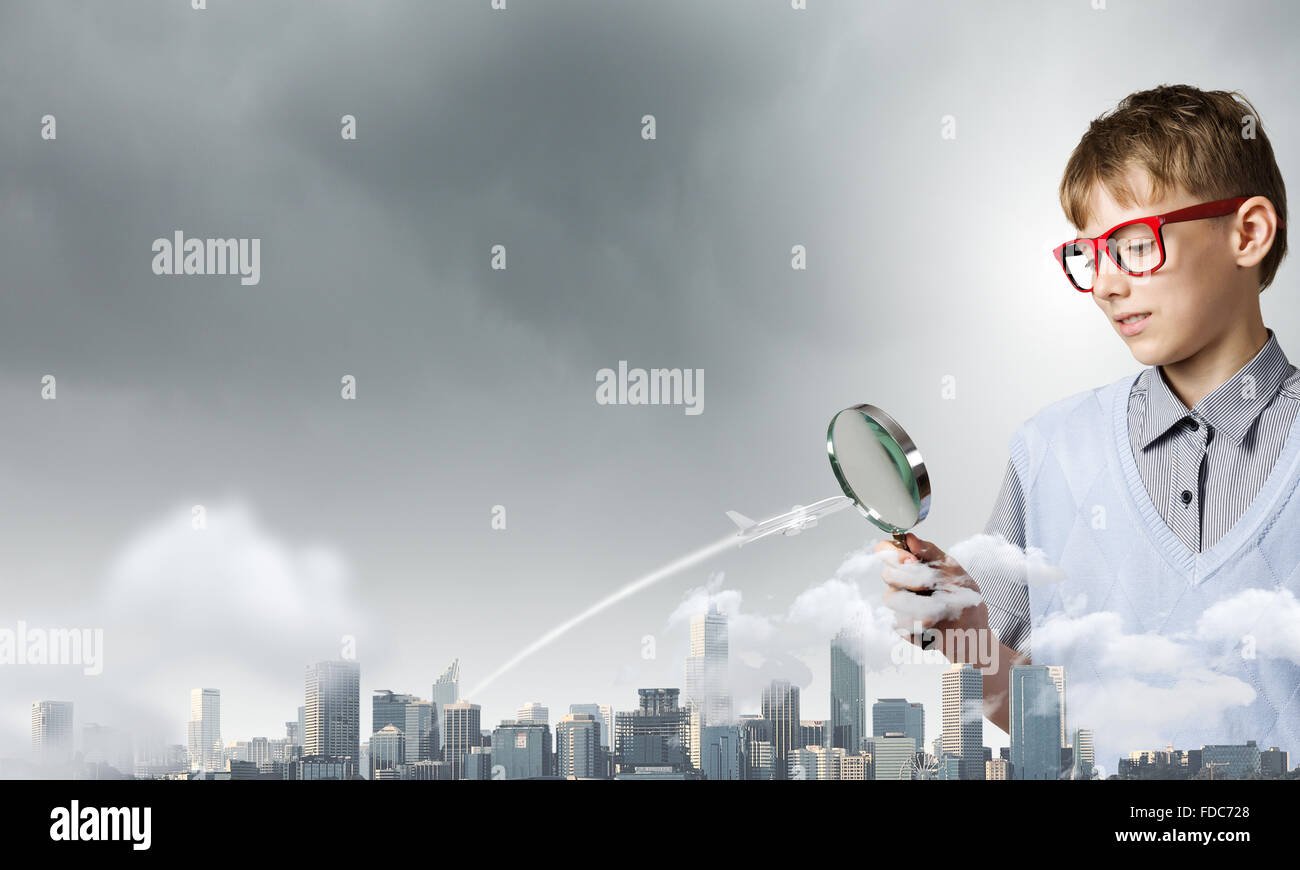 Cute school boy examining objects with magnifying glass Stock Photo - Alamy