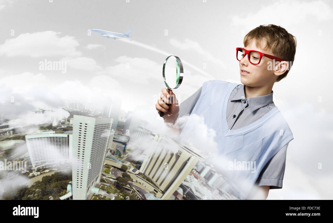 Cute school boy examining objects with magnifying glass Stock Photo - Alamy