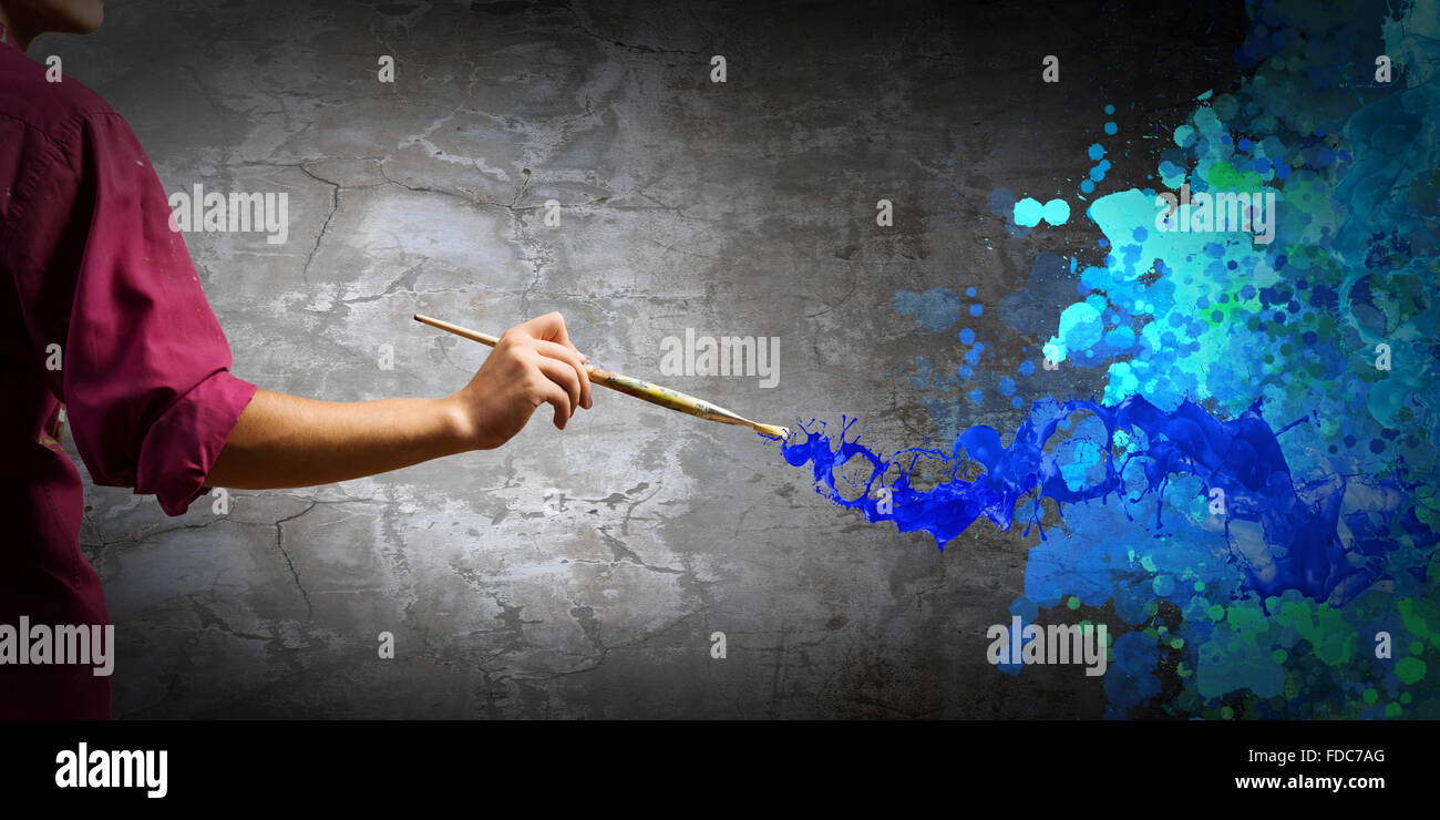 Young handsome man painter with brush in hand Stock Photo - Alamy