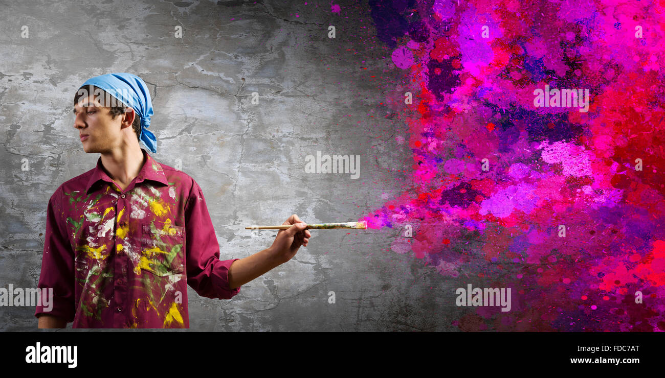 Young handsome man painter with brush in hand Stock Photo - Alamy