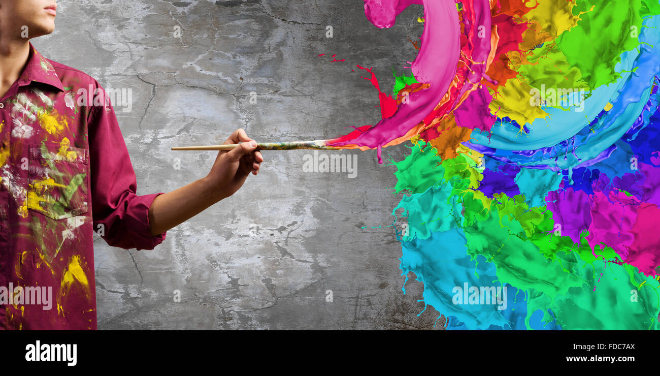Young handsome man painter with brush in hand Stock Photo - Alamy