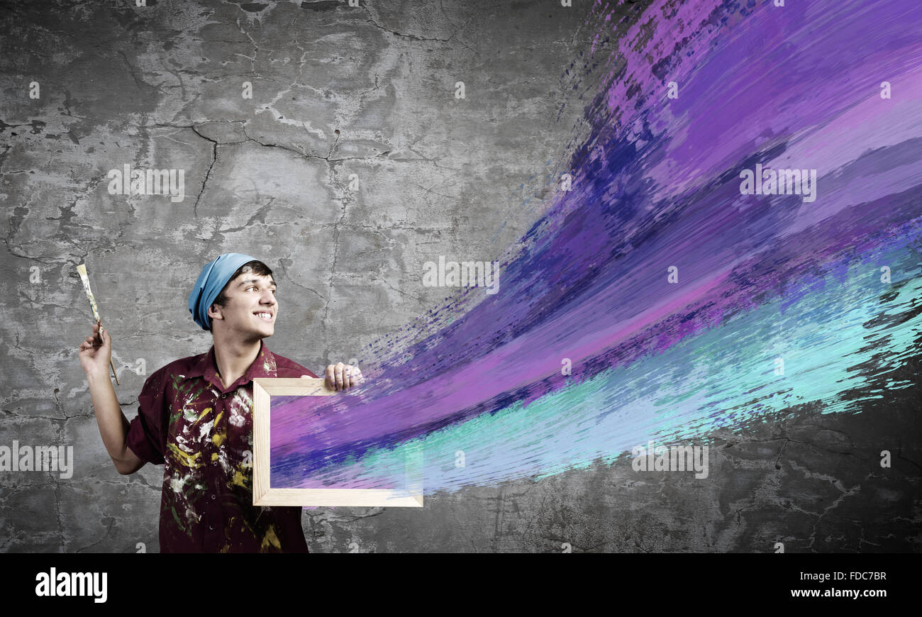 Young handsome man painter with brush in hand Stock Photo - Alamy