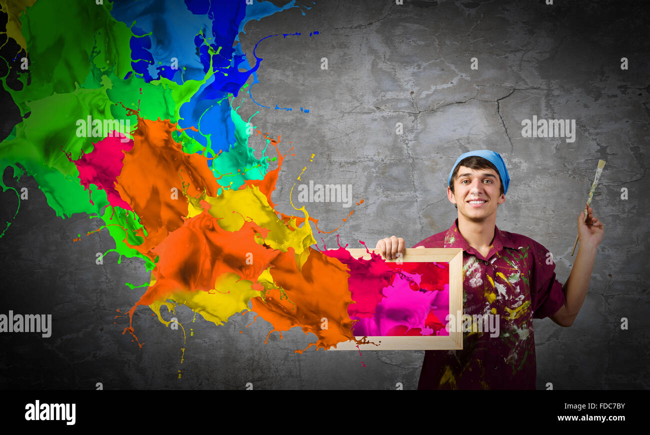 Young handsome man painter with brush in hand Stock Photo - Alamy