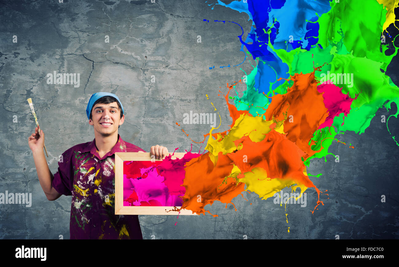 Young handsome man painter with brush in hand Stock Photo - Alamy