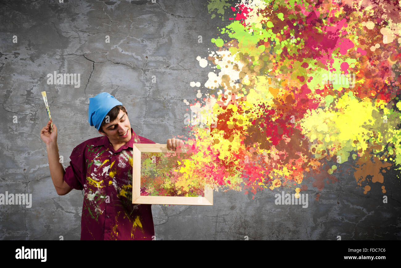 Young handsome man painter with brush in hand Stock Photo - Alamy