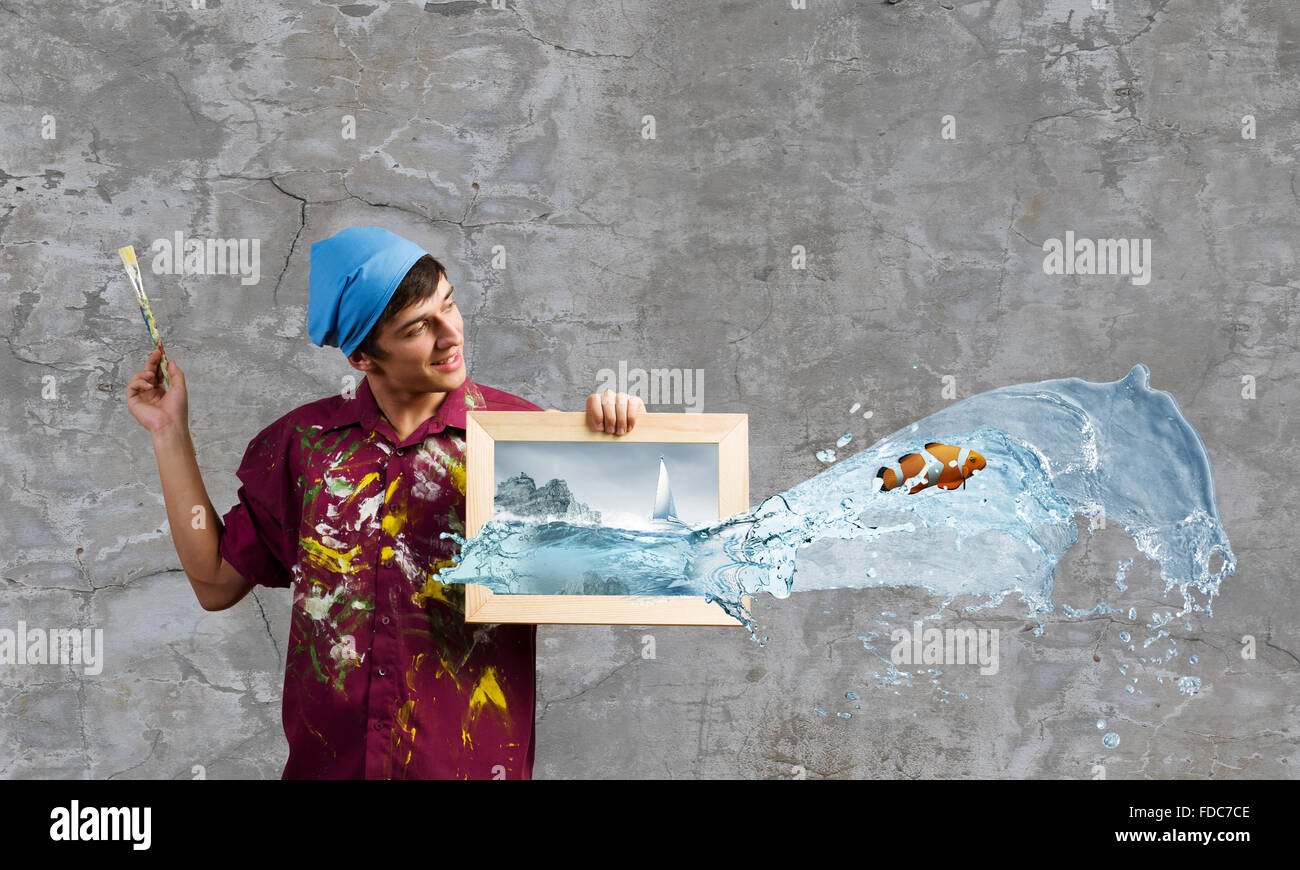 Young handsome man painter with brush in hand Stock Photo - Alamy