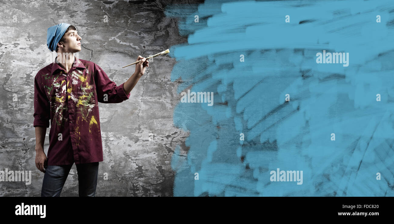 Young handsome man painter with brush in hand Stock Photo - Alamy