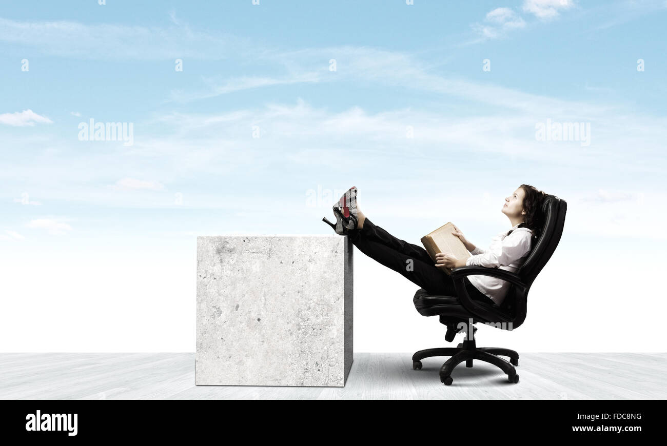 Young businesswoman sitting in chair and reading book Stock Photo - Alamy