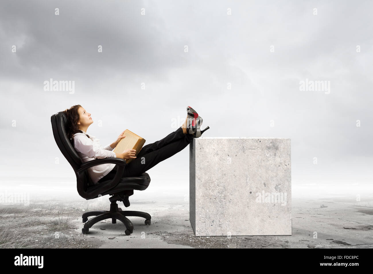 Young businesswoman sitting in chair and reading book Stock Photo - Alamy