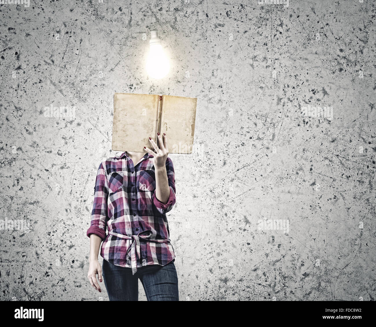 Young woman in casual hiding face behind reading Stock Photo - Alamy