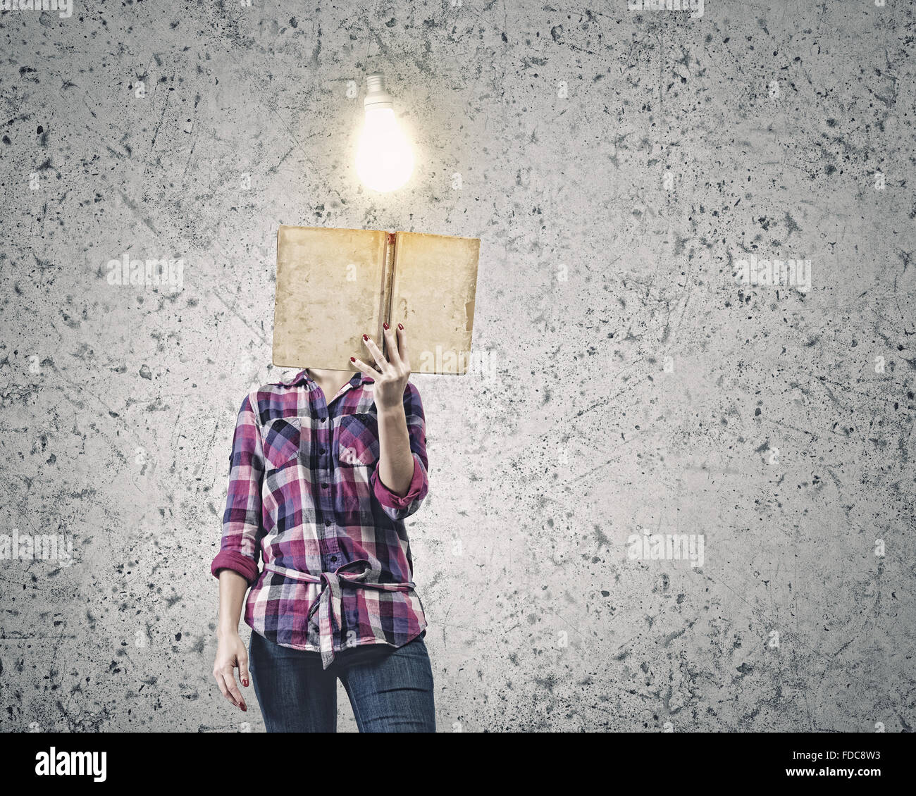 Young woman in casual hiding face behind reading Stock Photo - Alamy