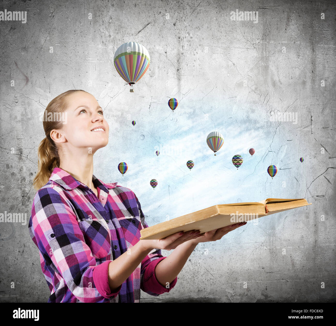 Young woman in casual hiding face behind reading Stock Photo - Alamy
