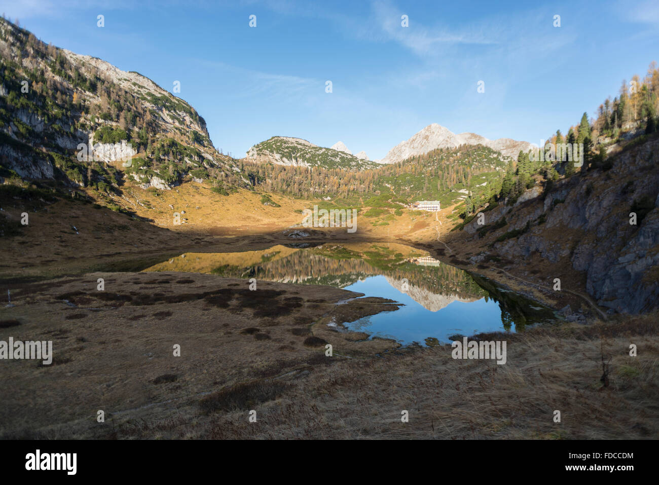 The Kaerlingerhaus mountain hut at sunrise reflected in lake Funtensee ...