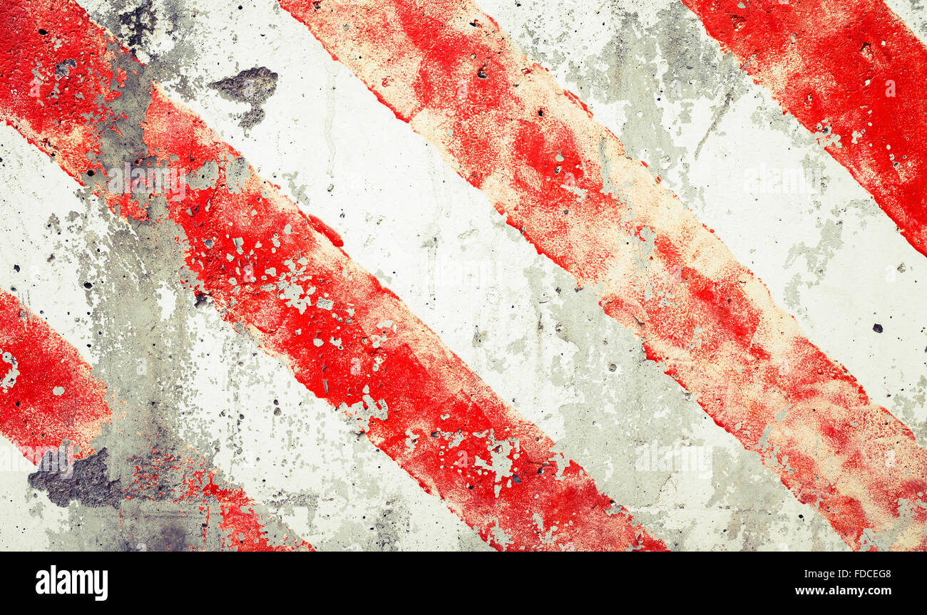 Striped red and white warning pattern over old grungy concrete wall ...