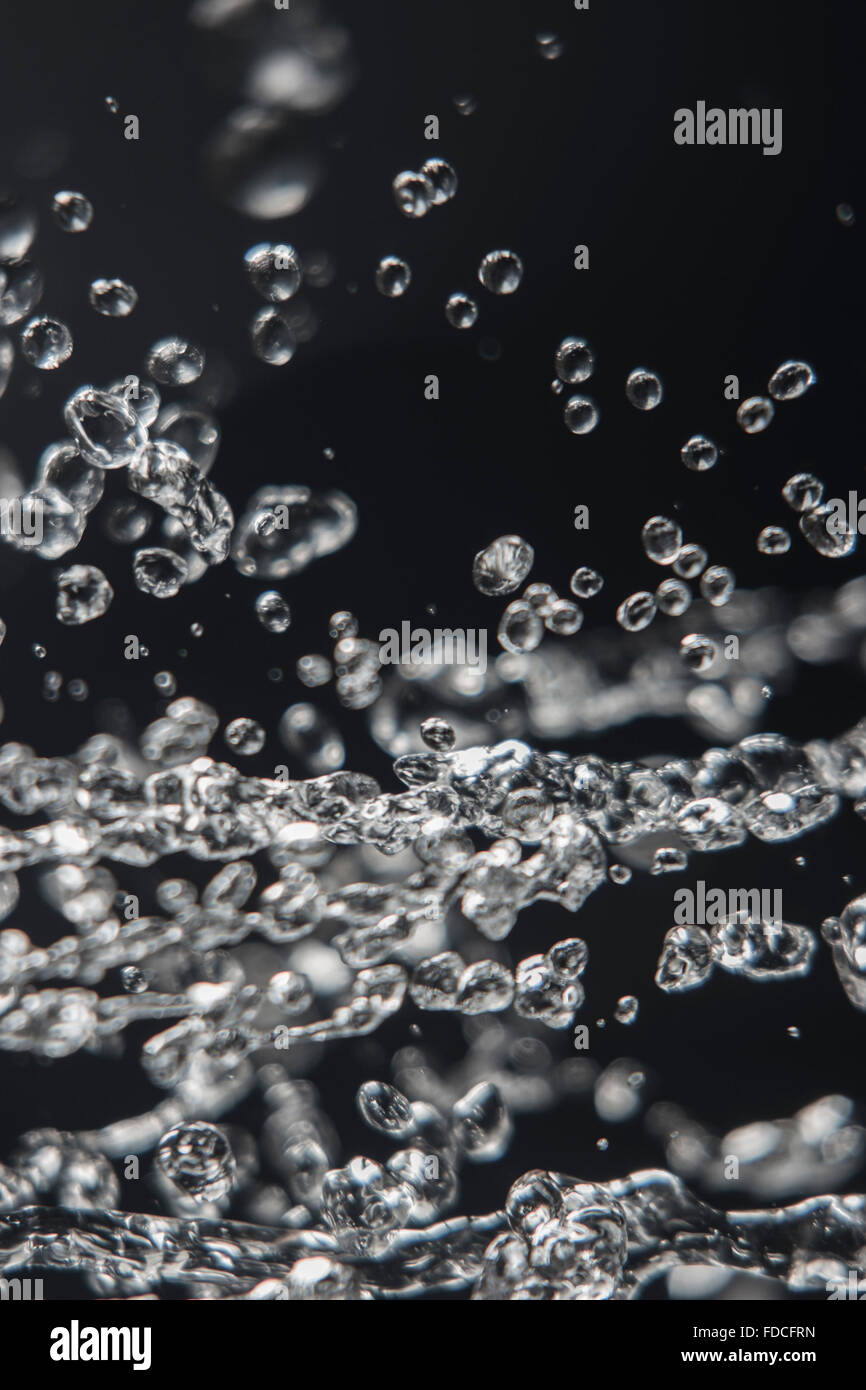 Levitation of water drops on black Stock Photo - Alamy