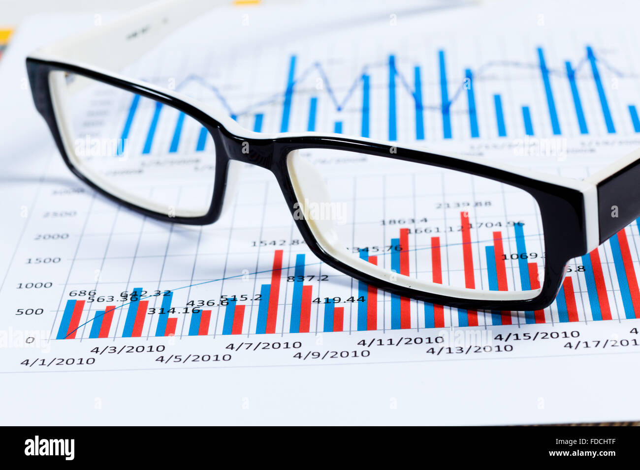 Eye glasses lying on papers with graphs and diagrams Stock Photo - Alamy