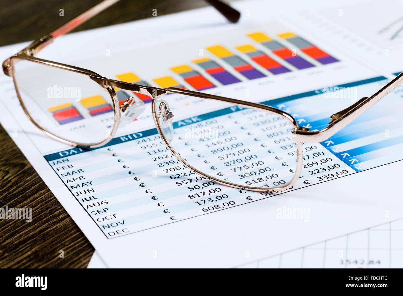 Eye glasses lying on papers with graphs and diagrams Stock Photo - Alamy