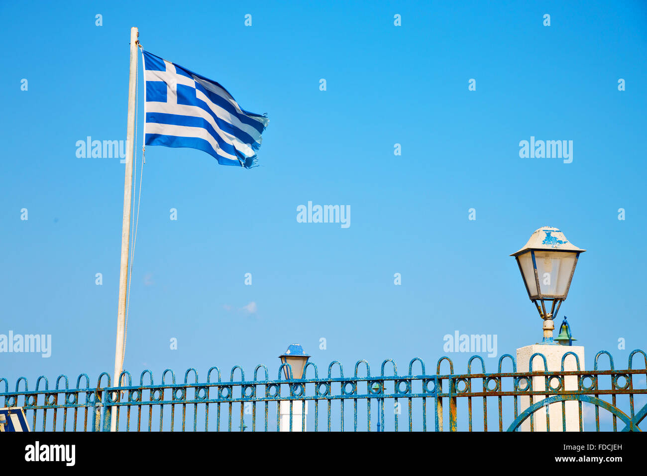 waving greece flag in the blue sky and flagpole Stock Photo - Alamy