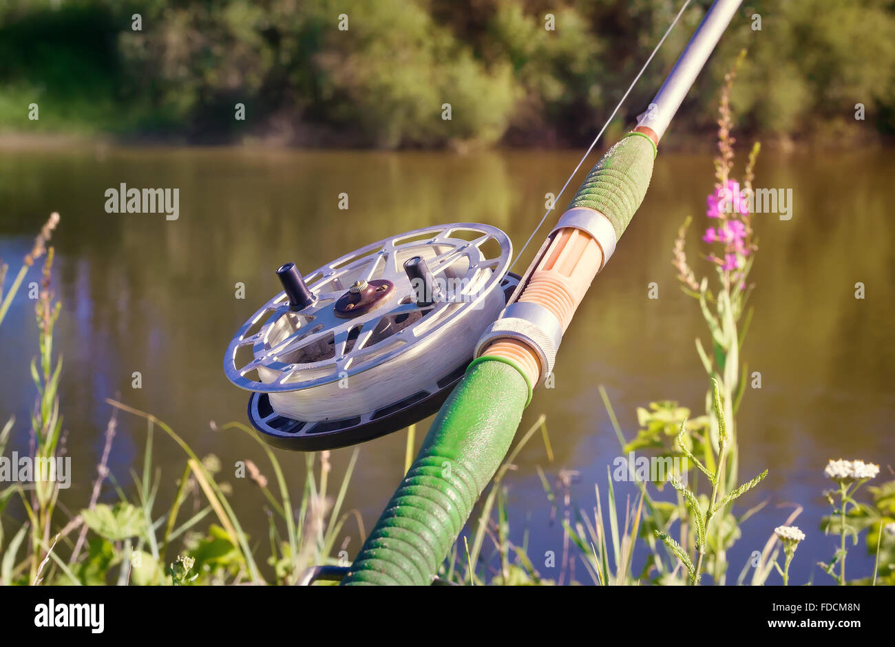 On the banks of the beautiful river over the water set fishing ...