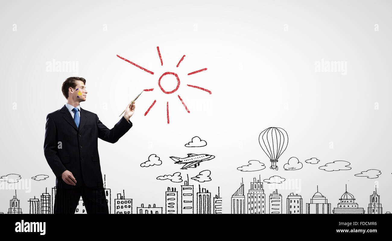 Young handsome man drawing sun with paint brush Stock Photo - Alamy