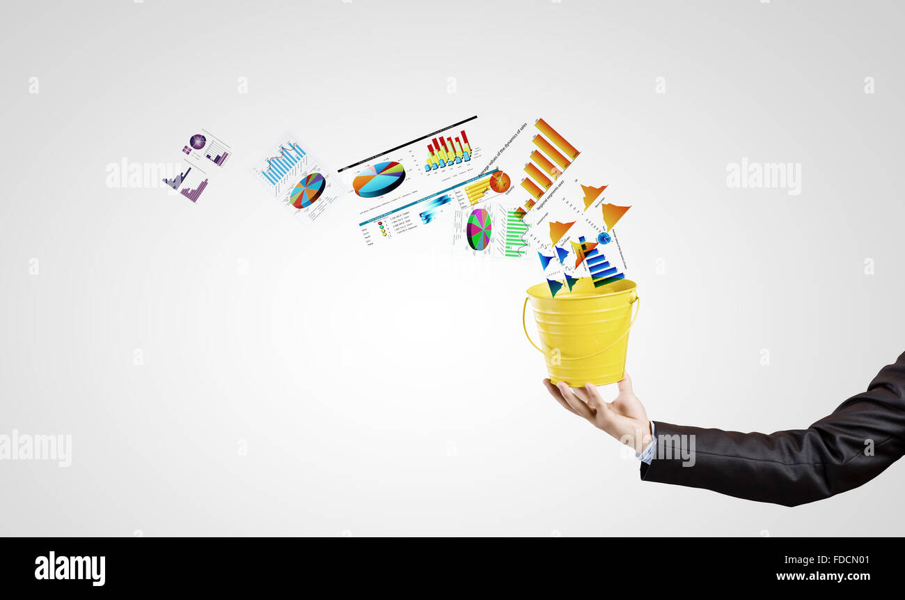 Man holding bucket with graphs and diagrams flying out Stock Photo - Alamy