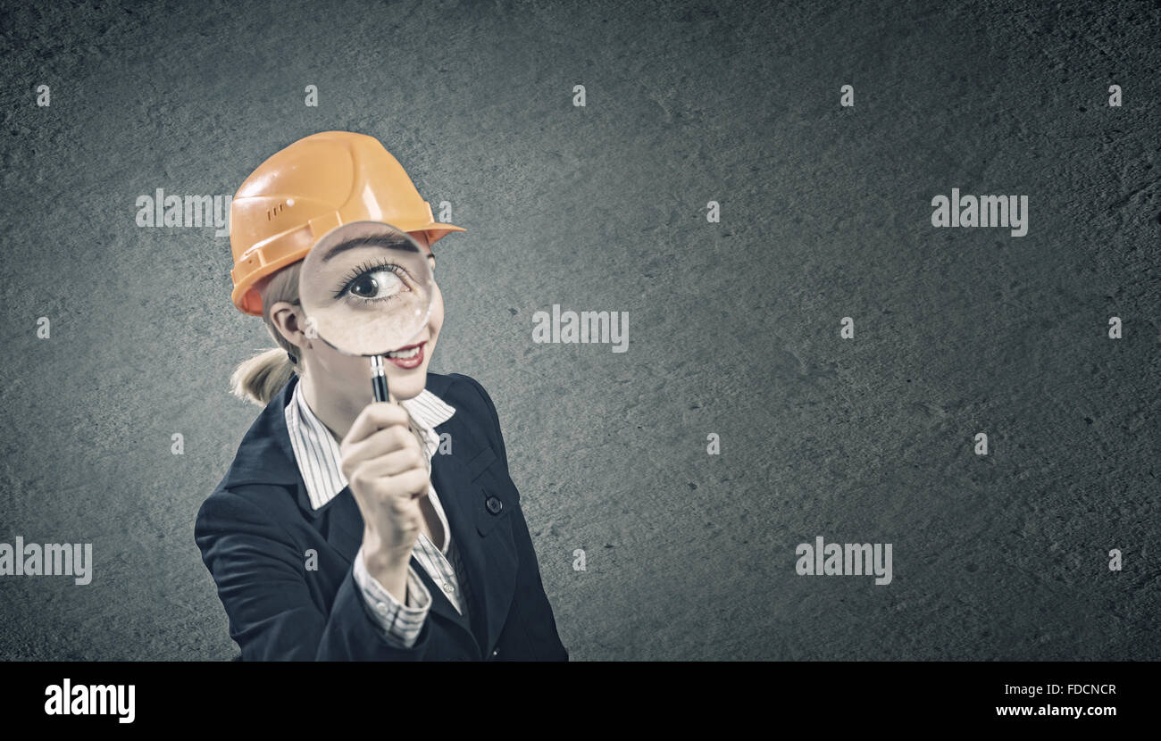 Young woman engineer looking in magnifying glass Stock Photo - Alamy