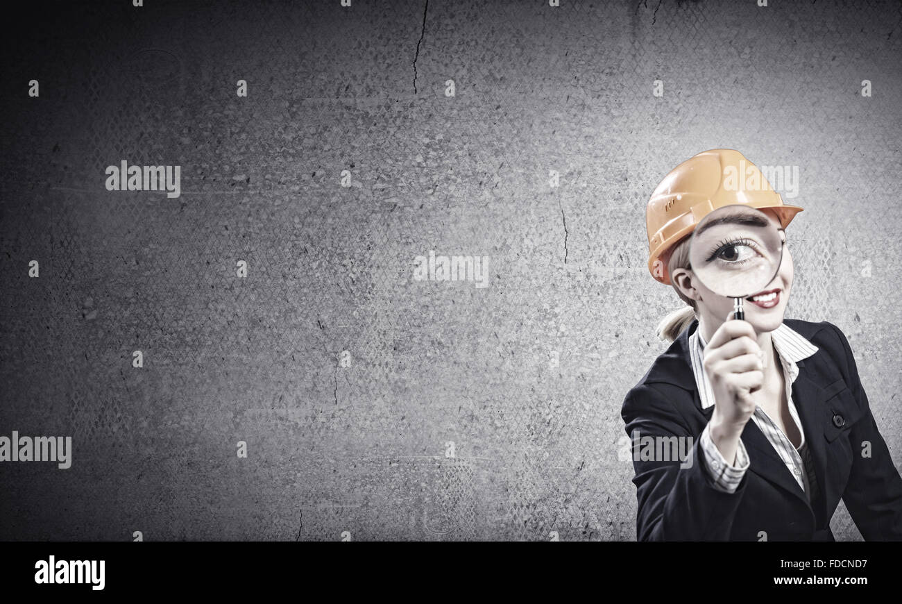 Young woman engineer looking in magnifying glass Stock Photo - Alamy