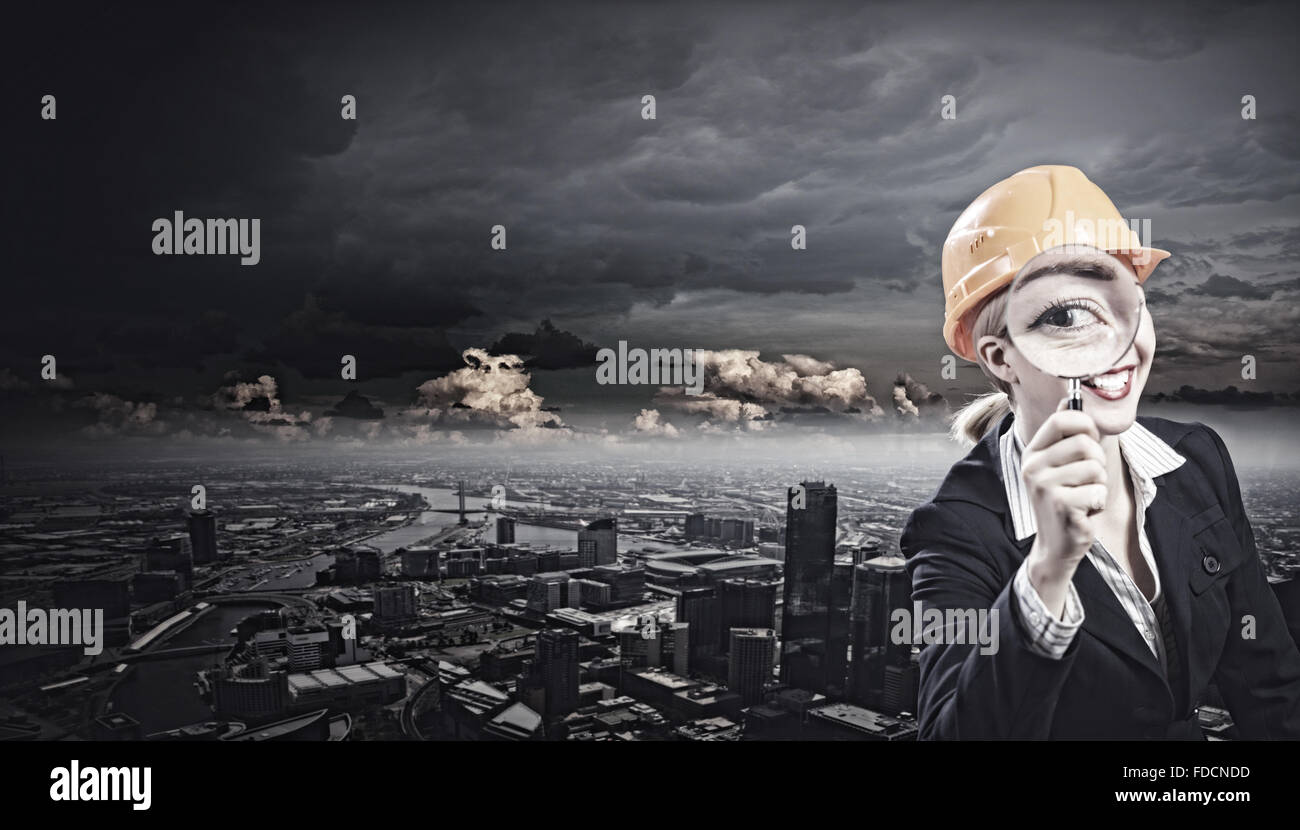 Young woman engineer looking in magnifying glass Stock Photo - Alamy