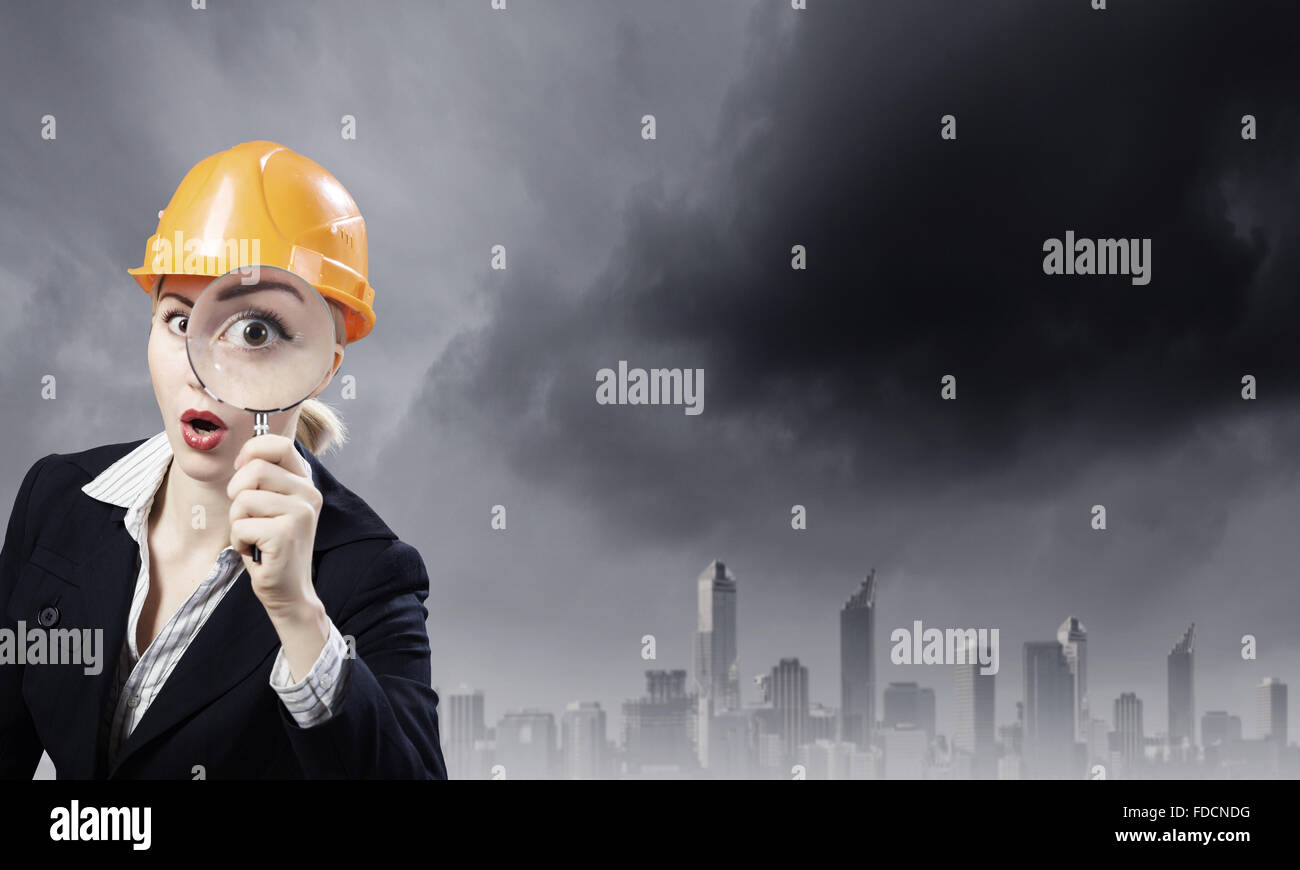 Young woman engineer looking in magnifying glass Stock Photo - Alamy