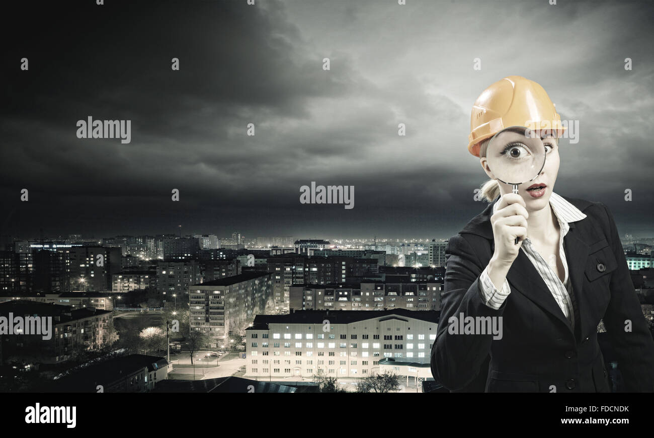 Young woman engineer looking in magnifying glass Stock Photo - Alamy