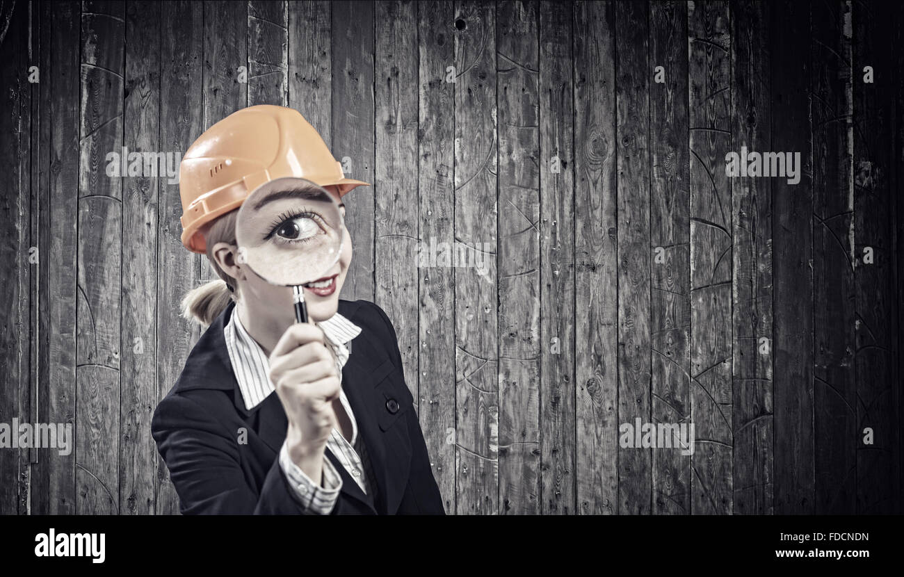 Young woman engineer looking in magnifying glass Stock Photo - Alamy