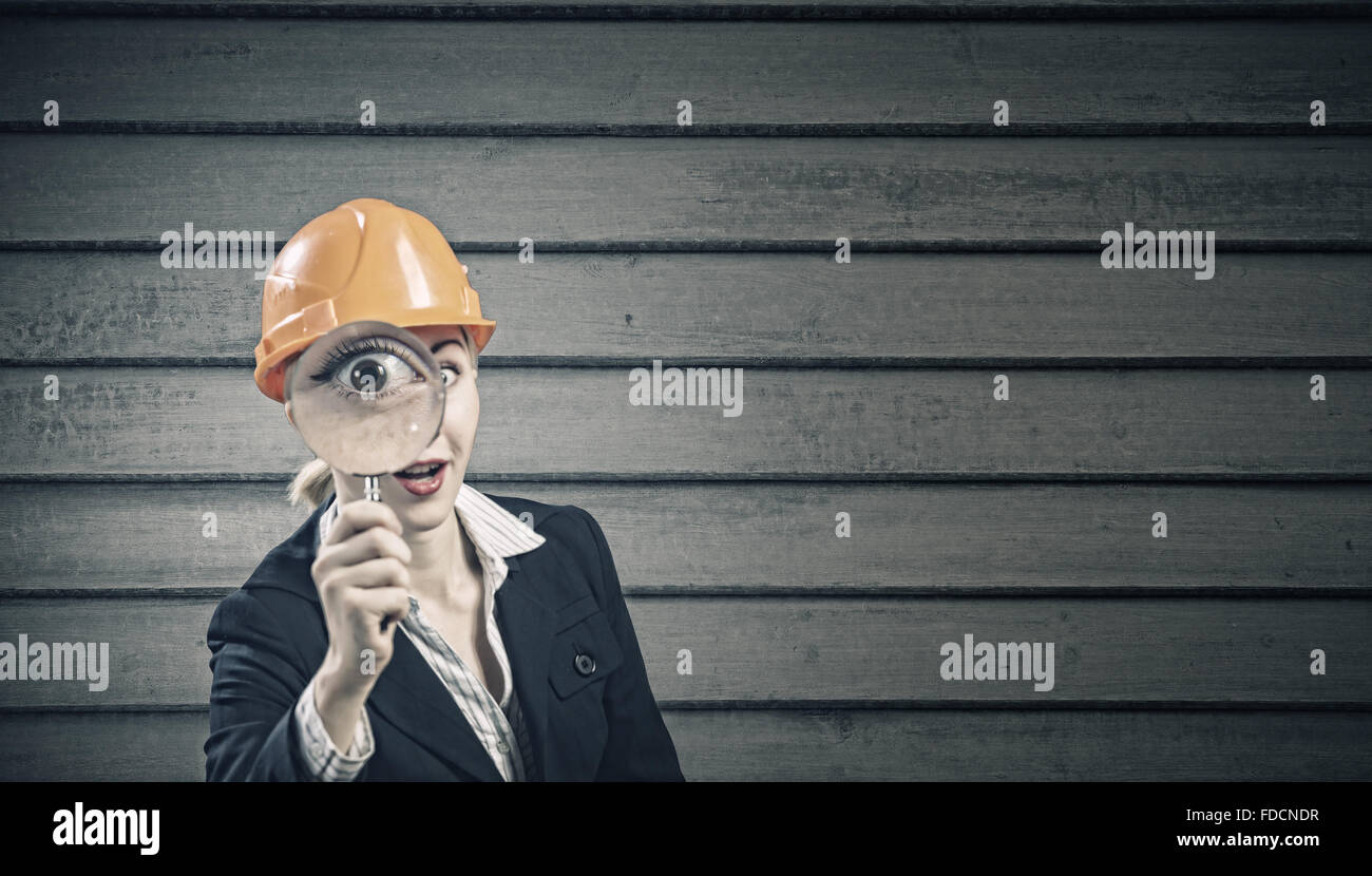 Young woman engineer looking in magnifying glass Stock Photo - Alamy