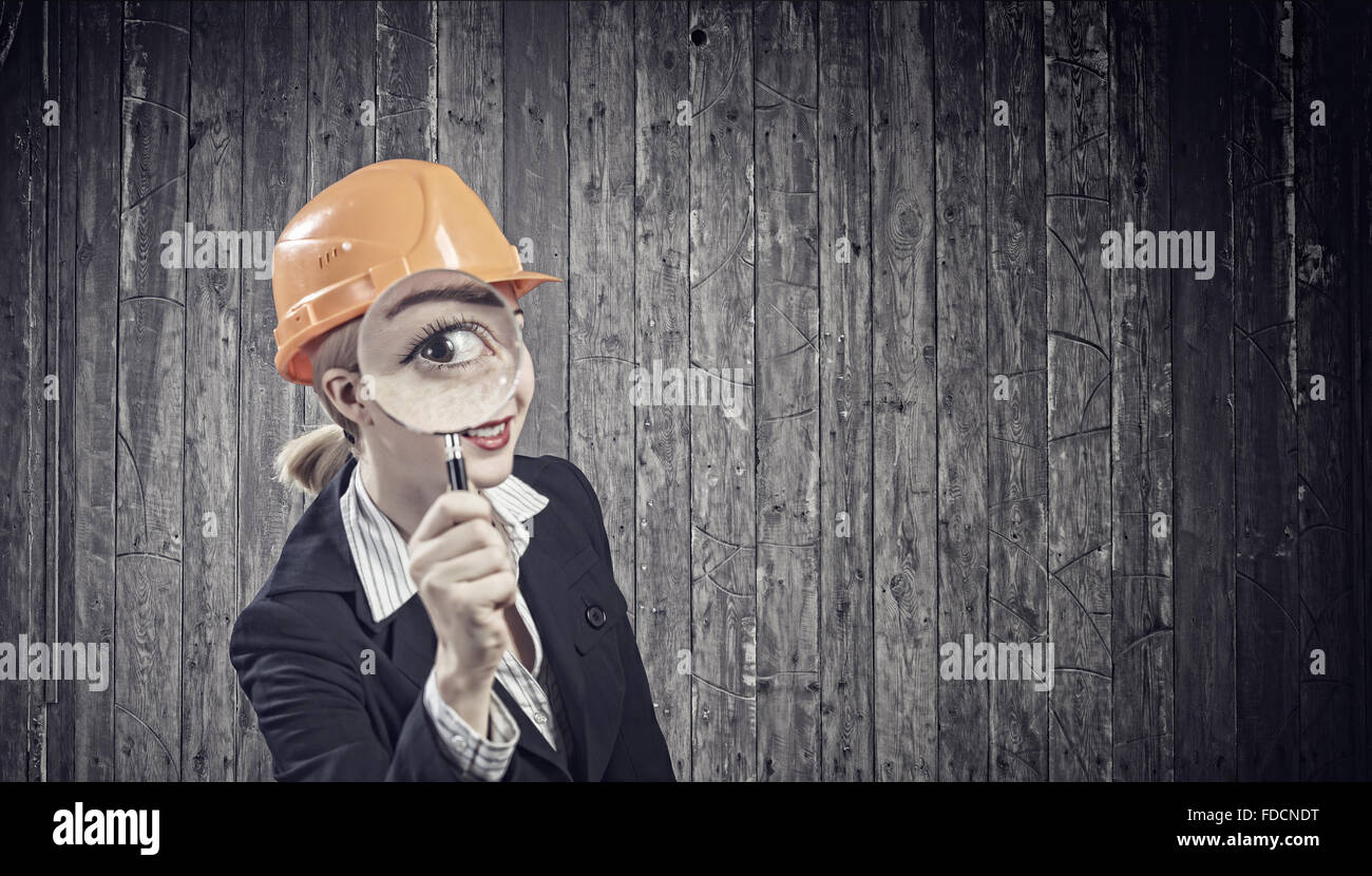 Young woman engineer looking in magnifying glass Stock Photo - Alamy