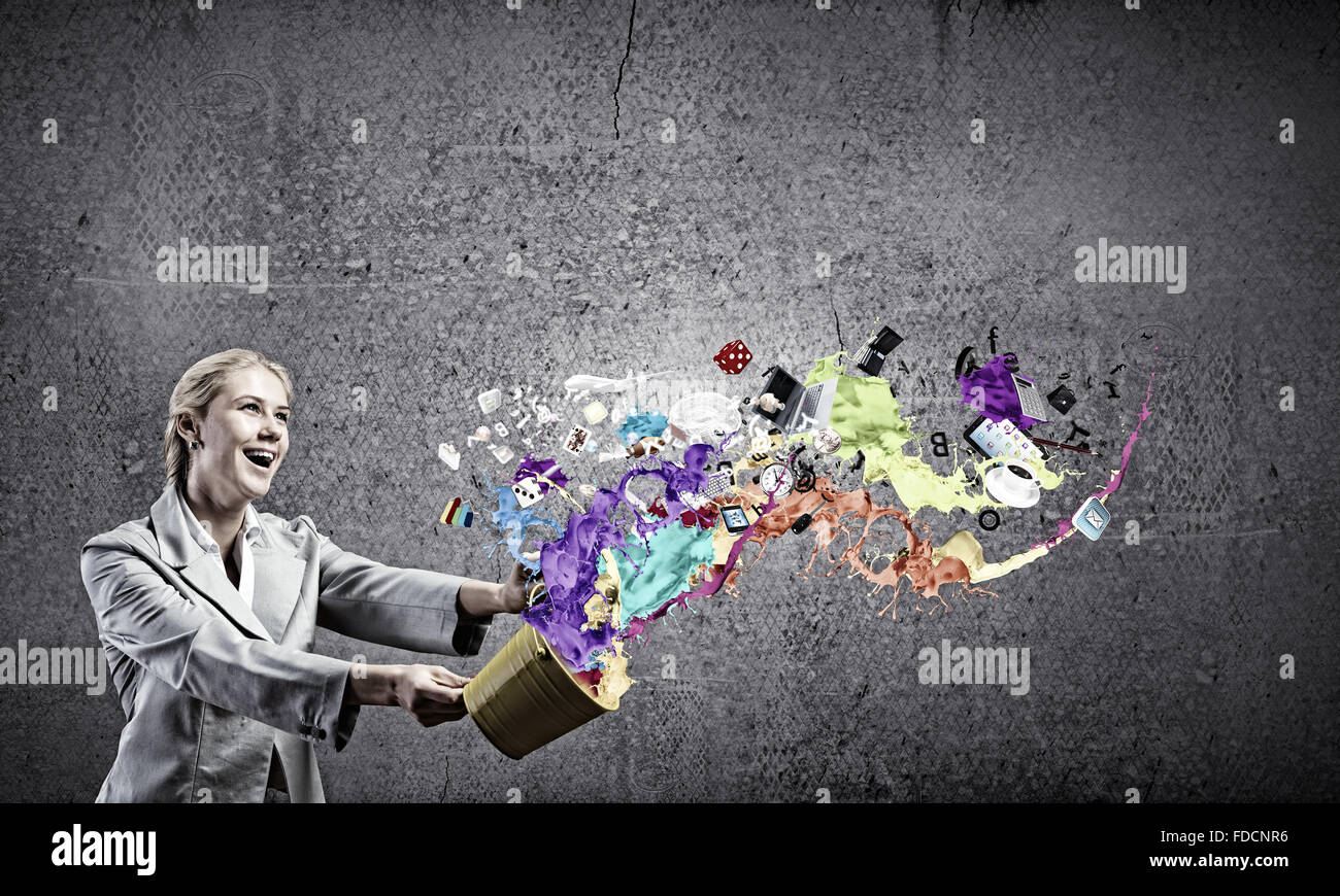 Young businesswoman holding bucket with paint splashes Stock Photo - Alamy