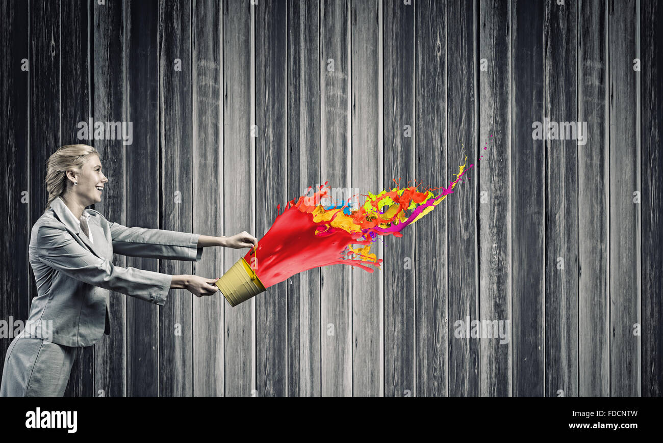 Young businesswoman holding bucket with paint splashes Stock Photo - Alamy