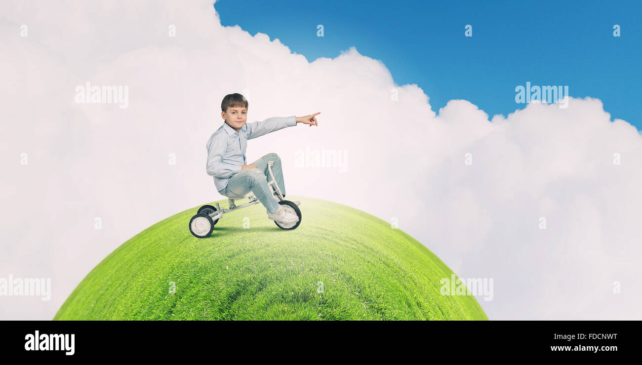 Little joyful cute boy riding tricycle on green grass Stock Photo - Alamy